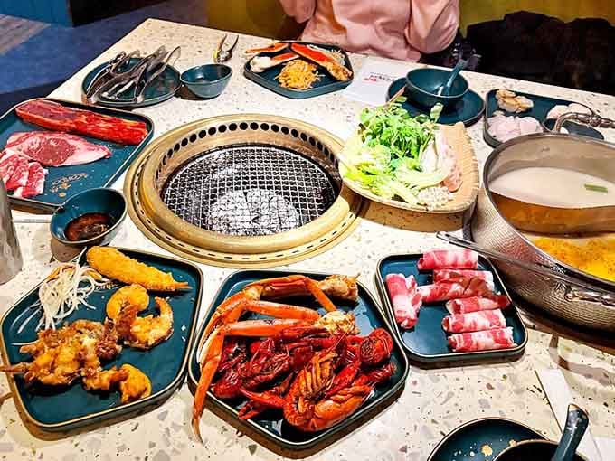 A table loaded with raw ingredients ready for their hot pot transformation, like a delicious science experiment you can eat.