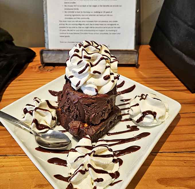 A towering chocolate brownie with whipped cream that makes every diet plan suddenly seem very negotiable and flexible.