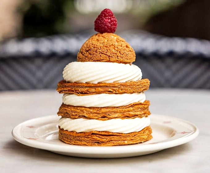 Layers of flaky pastry and cream stacked high with a raspberry crown make dessert feel like celebration.