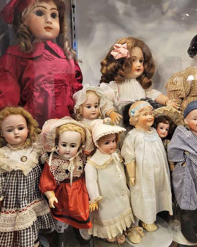 Antique dolls stare with those eyes that have witnessed more history than most textbooks could ever teach.