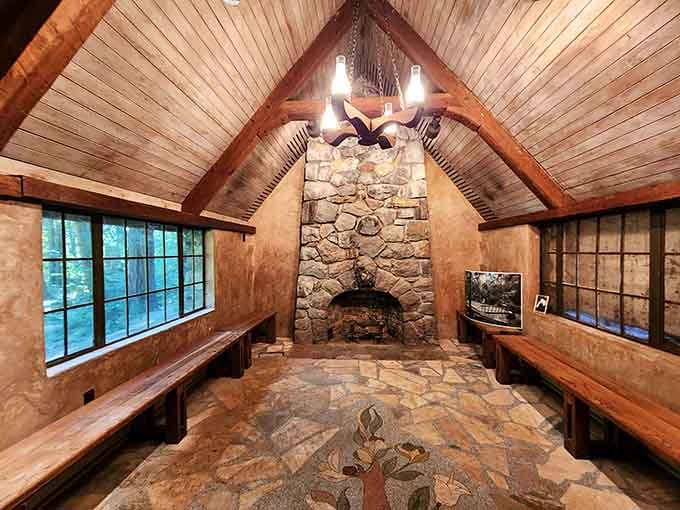 The rustic interior features a stone fireplace and wooden beams that radiate cozy cabin vibes year-round.