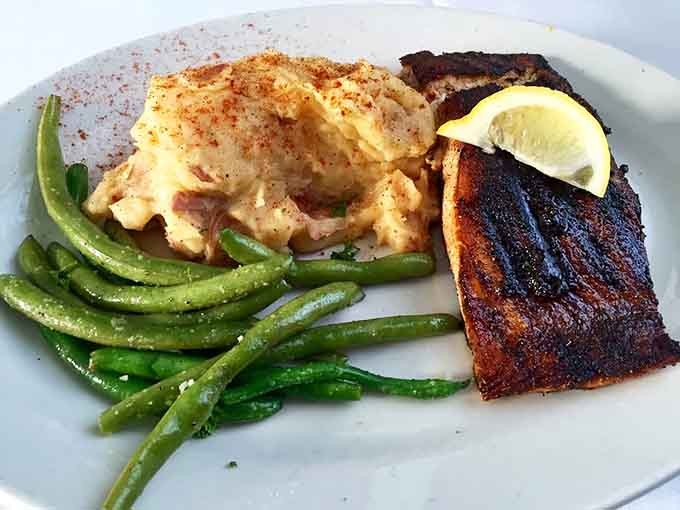Blackened salmon paired with lobster tail turns dinner into an occasion worth dressing up for, ghosts optional.