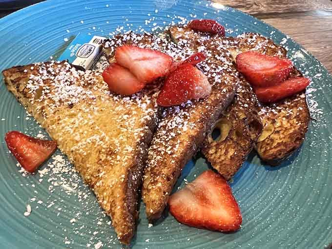 French toast dusted with powdered sugar and strawberries, golden and crispy like breakfast should always be.