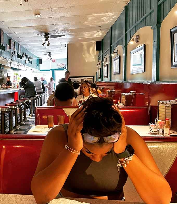 Diners enjoying their meals in those iconic red booths proves this place attracts folks who appreciate authentic nostalgia.
