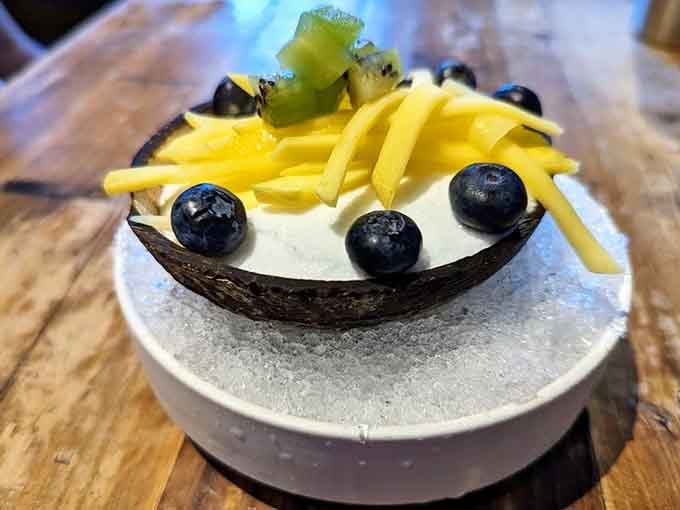 Coconut sorbet served in its own shell with mango and blueberries, a tropical finale worth saving room for.