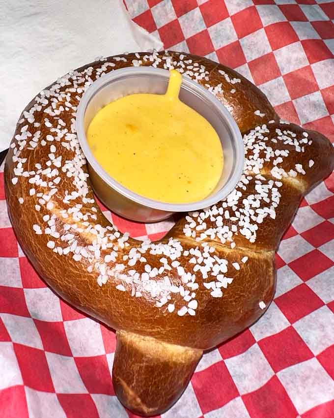 A pretzel the size of your head filled with cheese sauce is the kind of excess we can support.