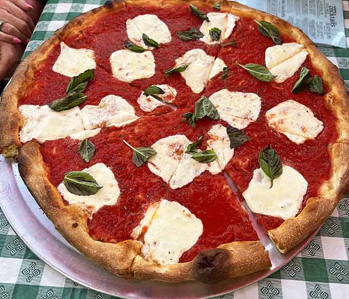 Fresh basil and mozzarella dollops transform this margherita into edible art that tastes even better than it looks.