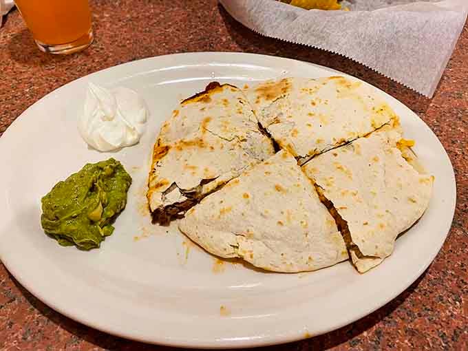 Golden quesadilla triangles with guacamole and sour cream standing by like the perfect supporting cast they are.