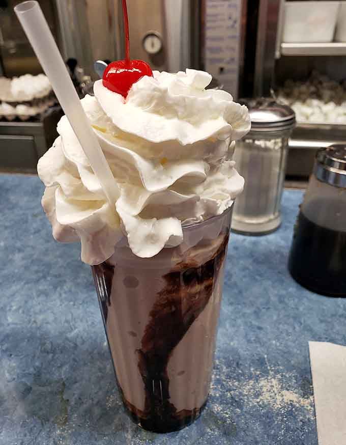 This milkshake mountain topped with whipped cream and a cherry demands both hands and zero regrets.