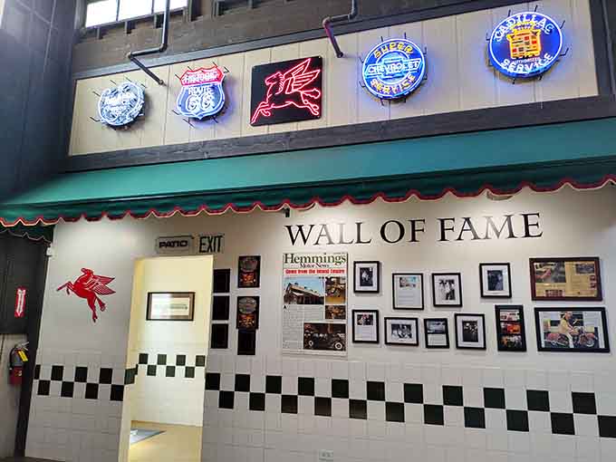 Vintage neon signs glow above checkered tile, celebrating automotive legends in a space that honors speed, style, and American ingenuity.