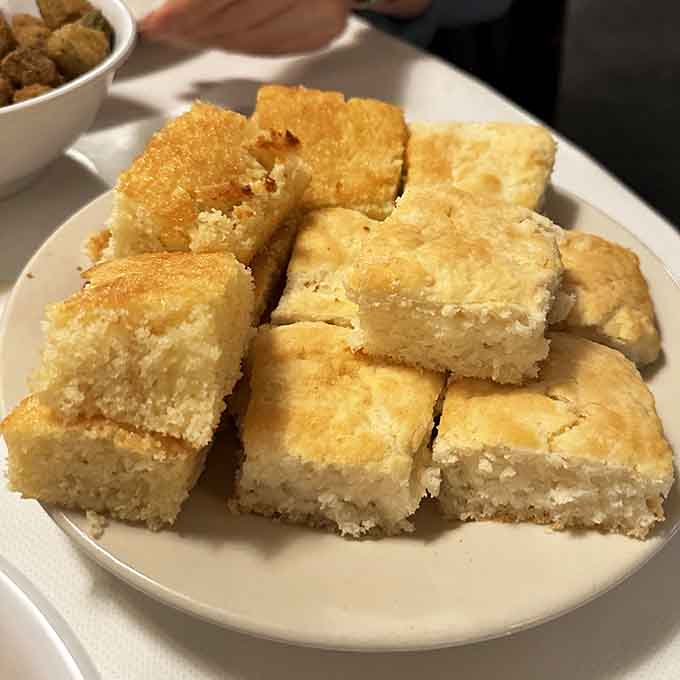 Cornbread squares cut just right, achieving that perfect balance between crumbly texture and moist, slightly sweet interior perfection.