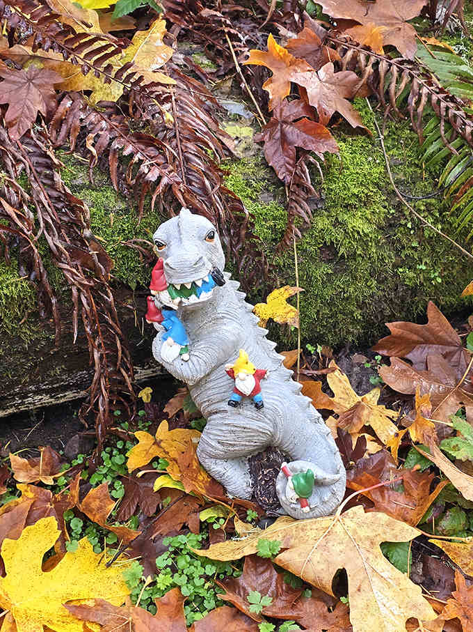 A friendly dinosaur joins the gnome party because apparently extinction doesn't apply when you're made of ceramic and pure joy.