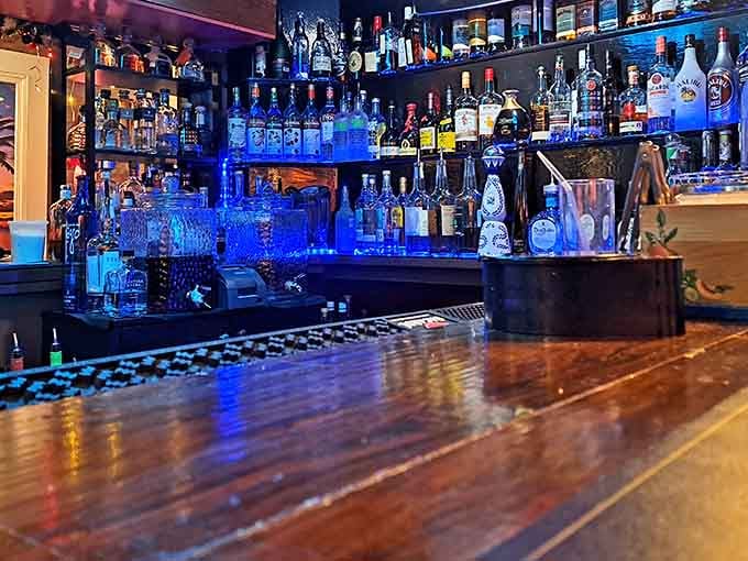 A bar that glows blue like a tropical dream, stocked with enough bottles to fuel countless vacation fantasies.