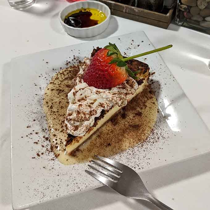 Cheesecake topped with a strawberry and dusted with cocoa proves that Italians understand dessert isn't just an afterthought here.