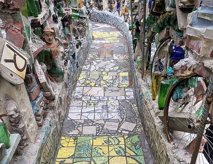 This narrow corridor lined with embedded bottles creates a shimmering tunnel effect that photographs simply cannot fully capture.