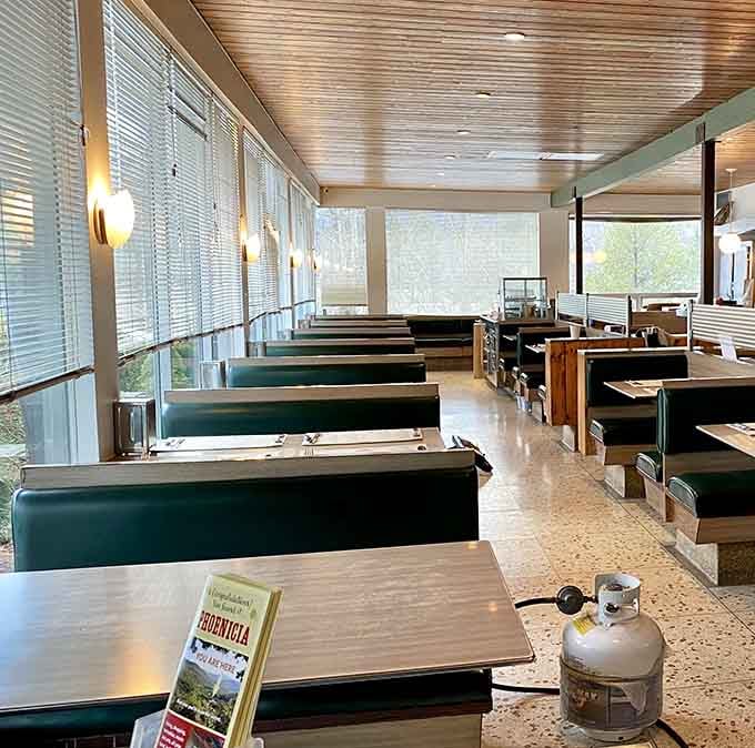 Those green vinyl booths and wood-paneled ceiling create the kind of cozy atmosphere that makes lingering feel mandatory.