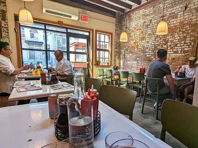 Those mint green chairs against weathered brick create the kind of unpretentious atmosphere where great food feels right at home.