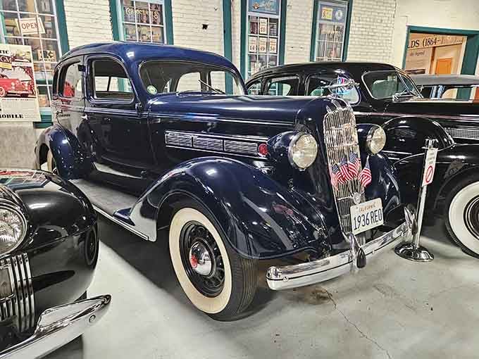 That deep blue beauty with the whitewall tires is pure automotive elegance from a more refined era.
