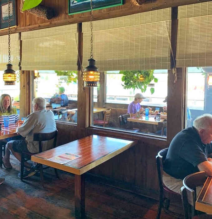 Diners enjoying their meals with river views, living proof that good food tastes better when water's involved somehow.