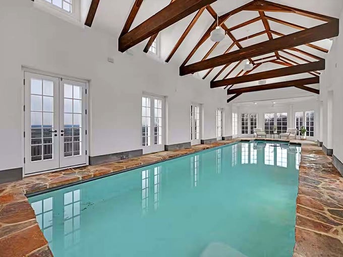 An indoor pool with timber beams overhead, because apparently swimming laps needed more architectural drama in its life.
