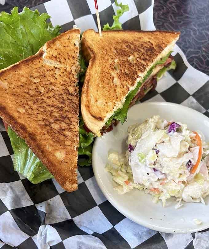 A BLT so perfectly constructed it deserves its own architectural award and coleslaw sidekick.