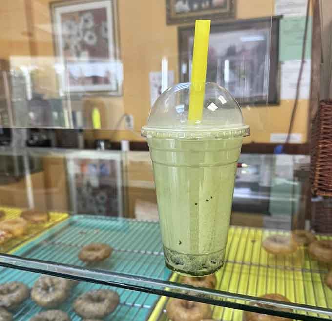 That vibrant green matcha boba drink provides the perfect complement to your sweet donut choices.
