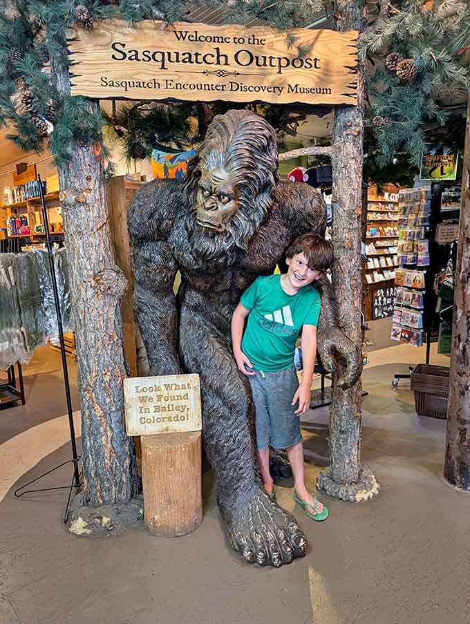 Nothing says "I believe" quite like a kid grinning next to a life-sized Sasquatch under the museum entrance sign.