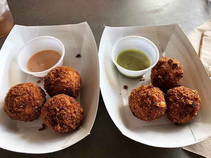Golden fried cue balls with dipping sauces, proving that everything tastes better when it's perfectly round.