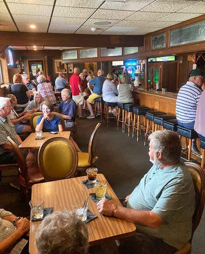 The bustling bar area where locals gather, stories flow, and everyone eventually becomes a regular given enough visits.