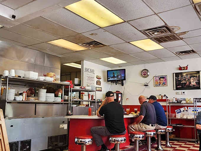 Classic diner counter seating where strangers become friends over coffee refills and shared appreciation for good breakfast.
