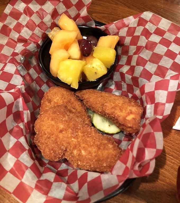 Breaded, fried, and served with fruit because even chicken strips deserve a fancy presentation sometimes.
