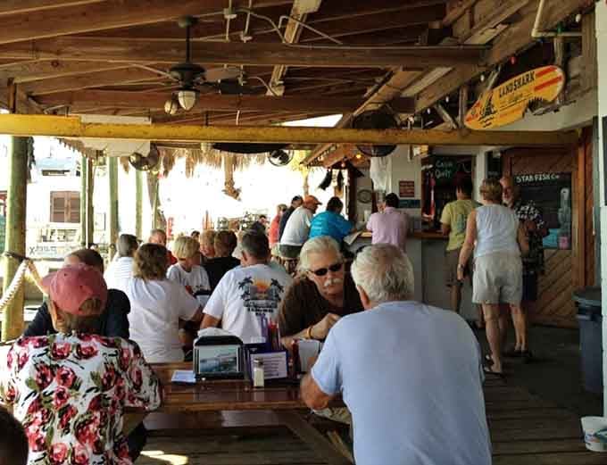 Happy diners enjoying waterfront views and fresh catches, living their best Old Florida life one delicious bite at a time.