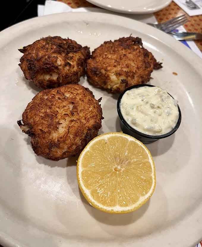 Three golden crab cakes with tartar sauce and lemon &ndash; proof that diners can deliver seafood that rivals any fancy coastal restaurant.
