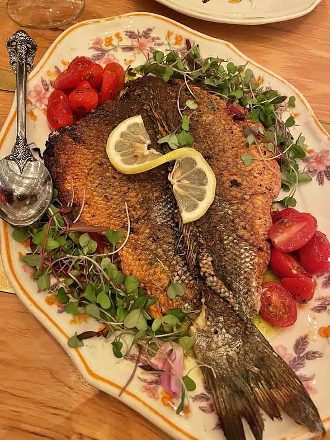 That whole branzino with lemon slices and fresh herbs looks like it swam straight from the Mediterranean to your plate.
