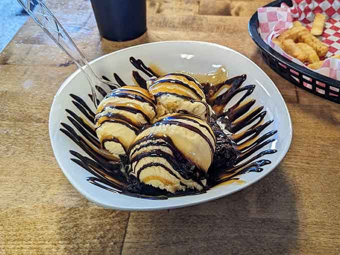 Brownie a la mode drizzled with chocolate sauce, because sometimes you need dessert to complete the experience.
