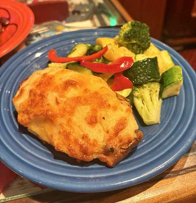 The chicken arrives golden and perfect, paired with vegetables so vibrant they practically glow on the plate.