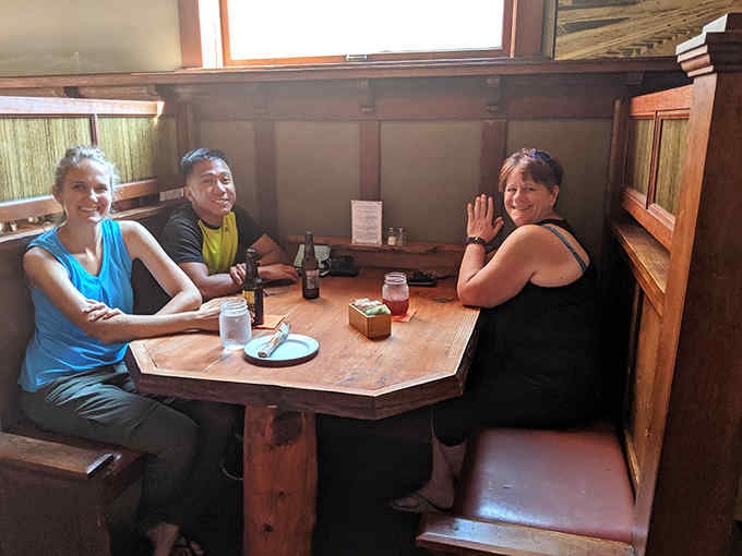 Those cozy wooden booths are where strangers become friends over shared slices and good conversation every night.