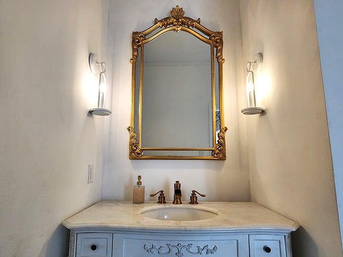 That mirror frame has more gold than a pirate's treasure chest, and the bathroom deserves every bit of glamour.