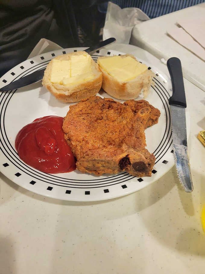 A perfectly seasoned pork chop with buttered bread proves this kitchen doesn't play favorites with their proteins.