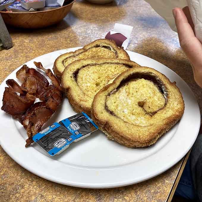 French toast so thick and golden it deserves its own Western movie, complete with a side of crispy bacon glory.