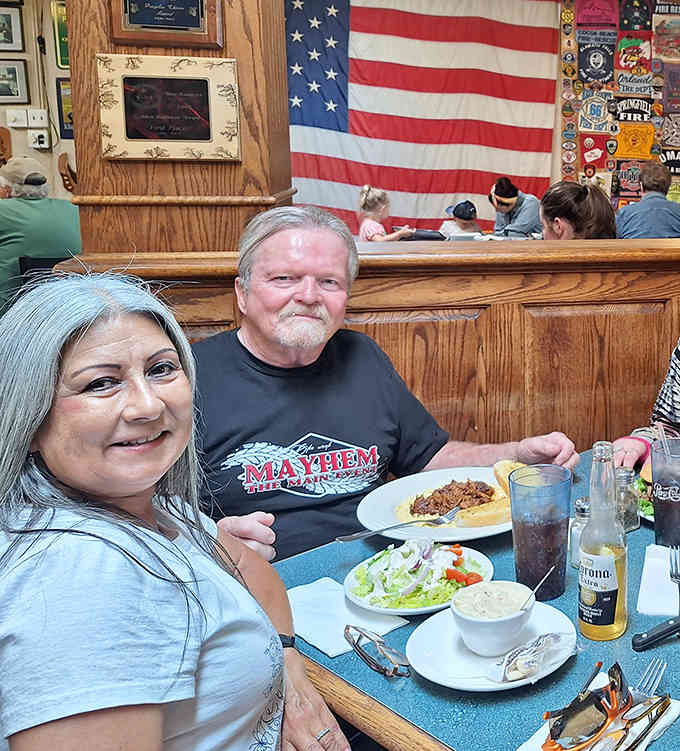Happy diners beneath the stars and stripes, enjoying good food in a space that celebrates American heroes and hospitality.
