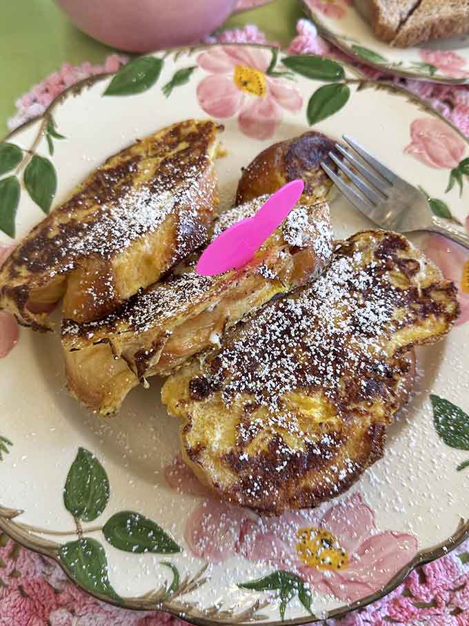 French toast dusted with powdered sugar glistens like breakfast gold, thick-cut and perfectly caramelized for maximum morning happiness and satisfaction.