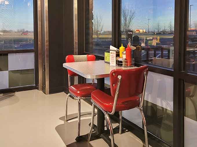 Chrome-trimmed tables and red vinyl chairs by the window offer prime people-watching real estate.