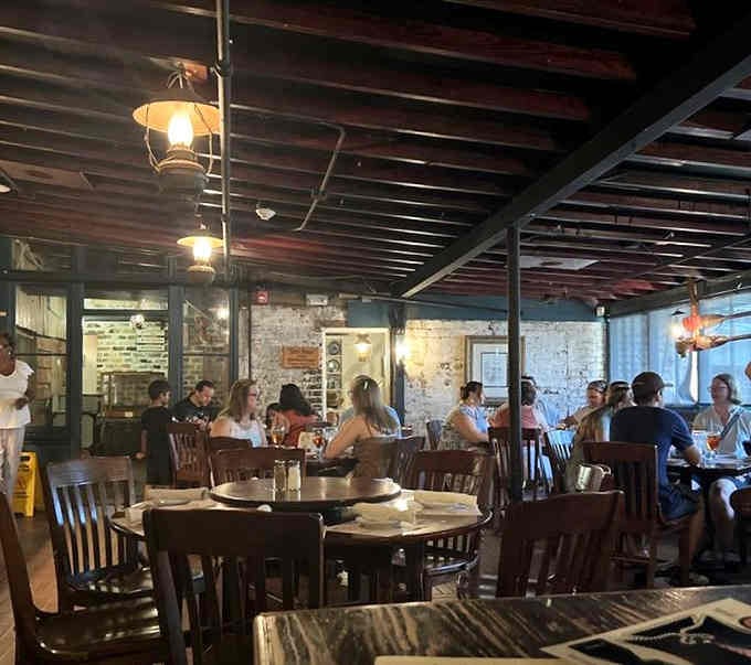 Diners enjoying the atmospheric glow of lantern light, sharing meals where history practically sits at every table beside them.