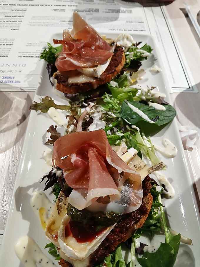 Fresh greens topped with prosciutto and burrata, proving that salads don't have to be punishment for last night's dessert.