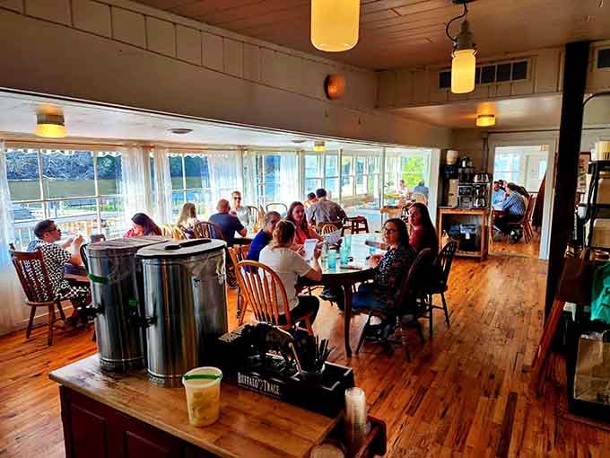 Happy diners in a sun-drenched room, living proof that good food creates the best kind of community gathering.