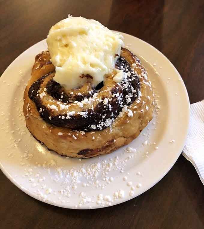 A cinnamon roll transformed into a hot cake with whipped cream, because regular pancakes were apparently feeling too modest.
