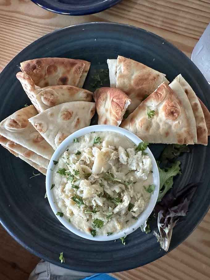 Warm pita and creamy crab dip create the kind of appetizer that starts friendly conversations and ends arguments.