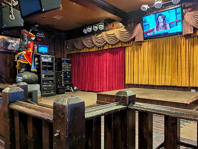 That stage area with red and gold curtains hints at entertainment possibilities beyond just dining.