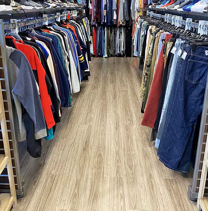 Men's clothing aisles stretching endlessly, proving guys deserve fashion options beyond three flannel shirts and hope.